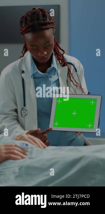 Vertical video: Specialist woman showing green screen on tablet to ...