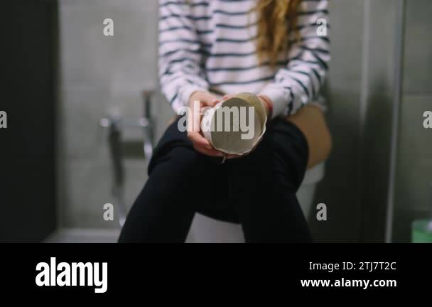 Low section of woman body sitting on toilet and suffers from diarrhea ...