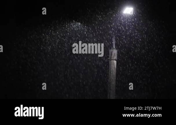 Double led panel lamppost under heavy rain at night. Midsize view of ...