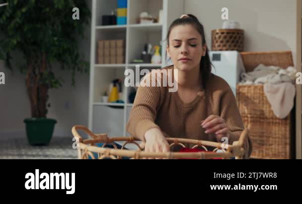 Young woman doing housework. She sits on bathroom floor and pulls out ...
