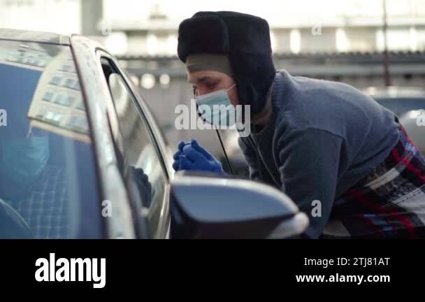 Side view homeless young beggar knocking on car window taking cash ...