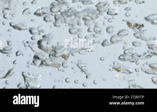 Air bubbles rising water surface closeup. Bubbling mineral liquid in ...
