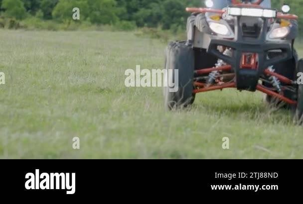 close-up of an ATV speeding through the woods. The wheels of an ATV ...