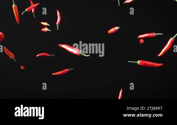 Falling red chili peppers on the dark black background. 4K UHD ...