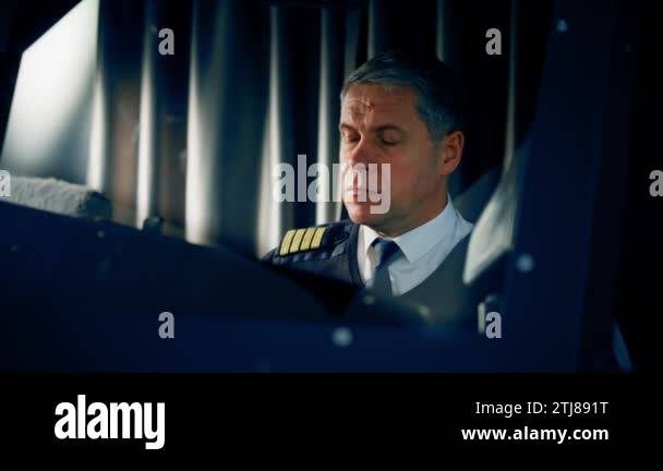 serious pilot of a modern passenger plane during flight in the cockpit ...