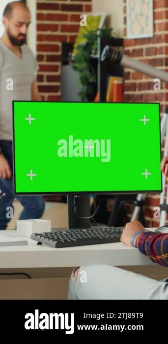 Vertical video: Office worker analyzing greenscreen template on monitor ...