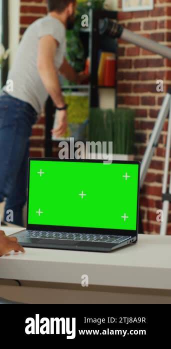 Vertical video: Office worker wearing headset and using laptop with ...