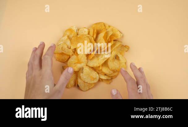 hands taking potato chips from the table top view, salty cheese snack ...