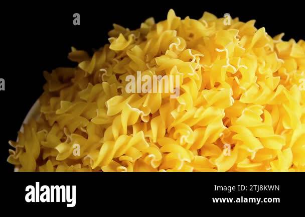 Uncooked Fusilli Pasta Heap Rotating against Black Background. Fat and ...
