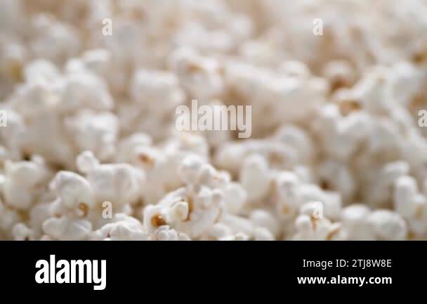 Mixing fresh hot popcorn. Close-up of popcorn production in slow motion ...