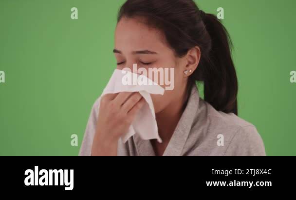 Young millennial girl blowing your nose on green screen. On green ...