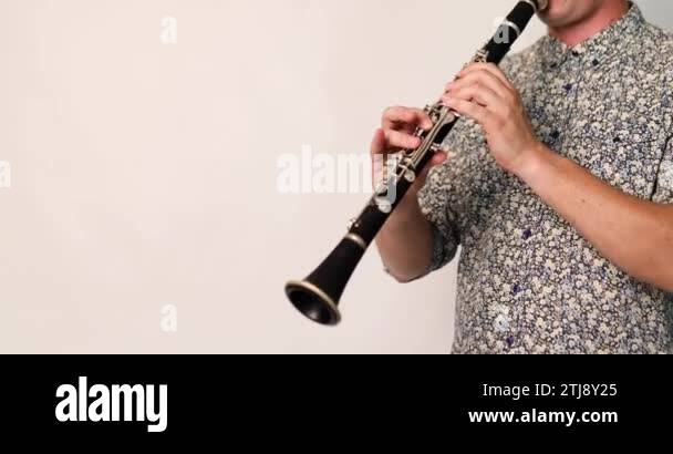 Man musician playing classic wind instrument clarinet on white ...