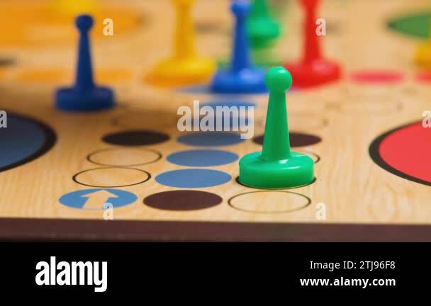 People play Ludo or Pachisi board game on beautiful wooden play board ...