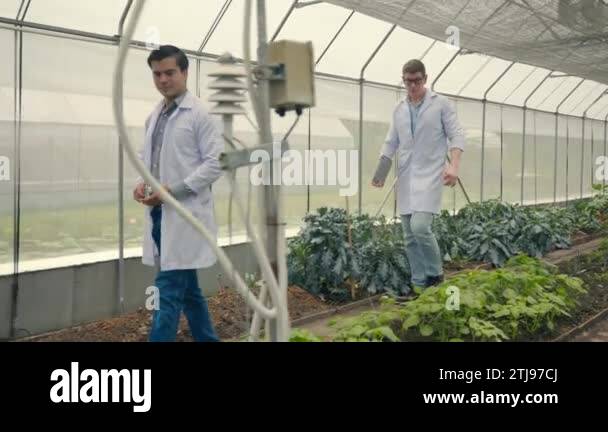 Two Biotechnology man engineer holding magnifying glass walking at the ...