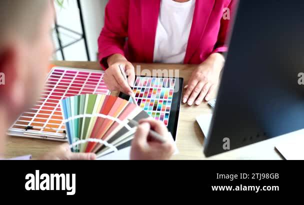 Woman working with color palette and tablet in office discussing color ...