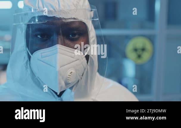 Close-up portrait of male African American doctor in white hazmat suit ...