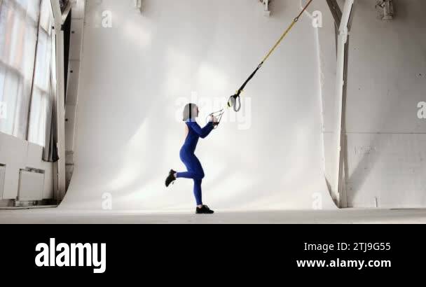 A fit woman in athletic gear performs one-legged squats with a forward ...