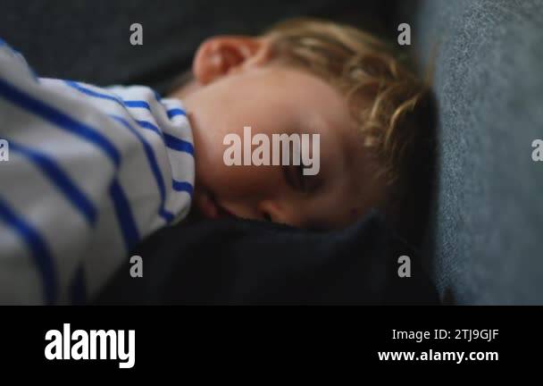 Little boy sleeping on couch close-up feet and toes slouched asleep ...