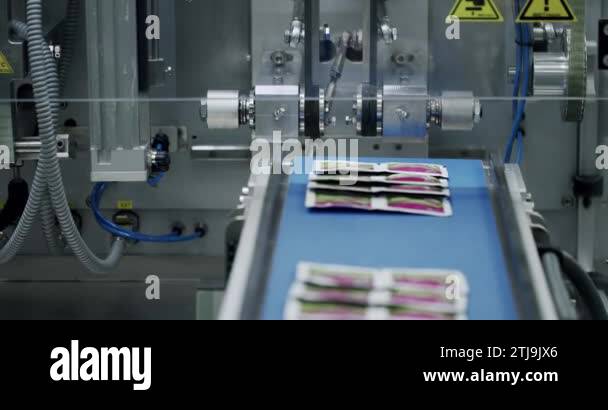 Manufacturing line at medical factory. Robotic arm put medicine package ...