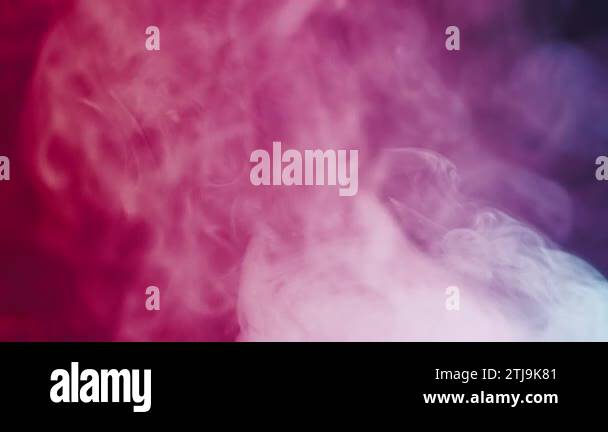 Swirling white smoke billows up against a black background, illuminated ...