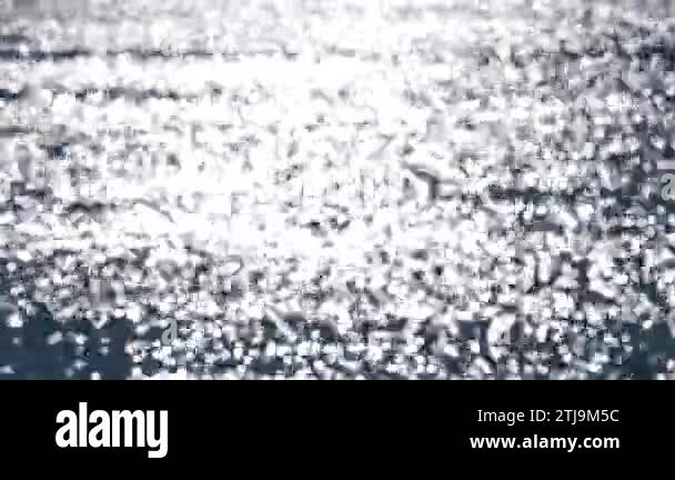 Abstract blurred background.Spots of white reflections of shining sun on blue surface of sea ...