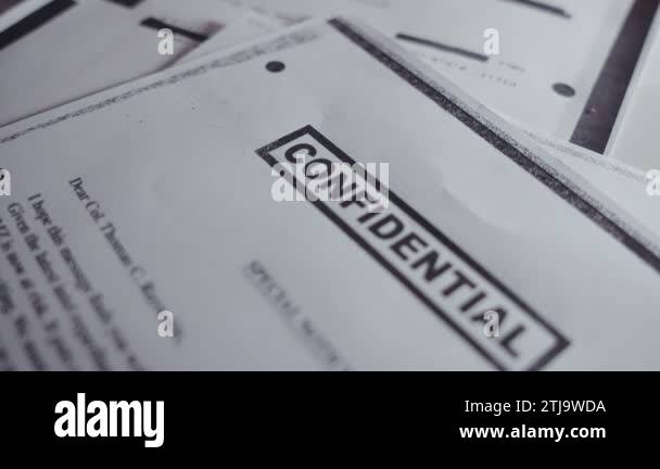 Close up on top secret papers and classified documents stacking up on ...