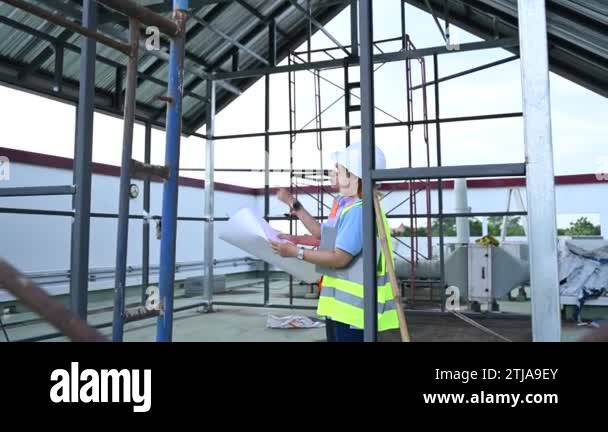 Young engineers working. Plan for construction of a warehouse. See the ...