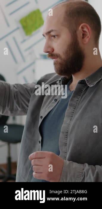 Vertical video: Close up of man architect looking at building model and ...