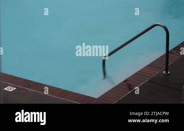Rain Drops Falling Into Outdoor Swimming Pool With Steps And Metal Rail ...