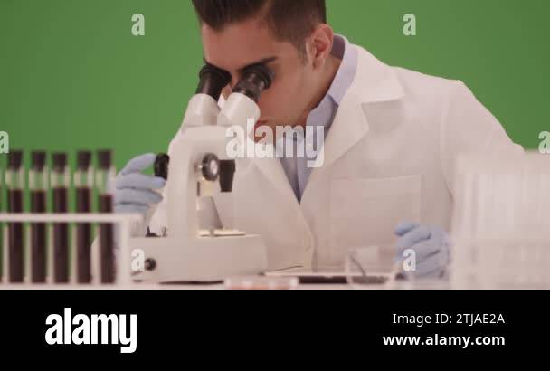 Millennial Hispanic medical scientist looking through microscope on ...