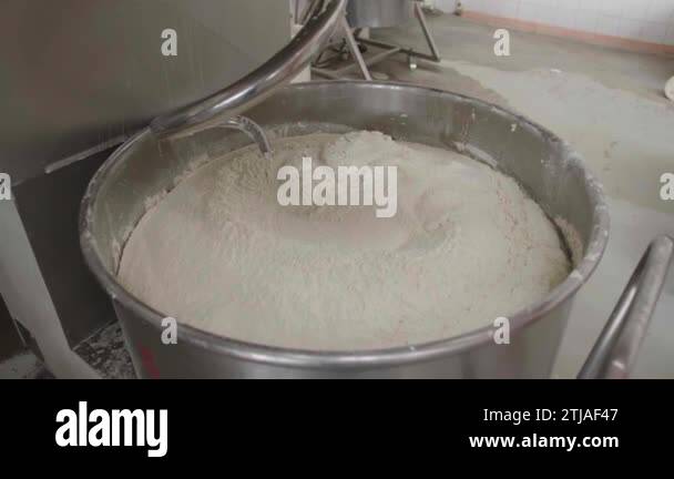 Metal barrel container with flour into which a spinning screw device is ...