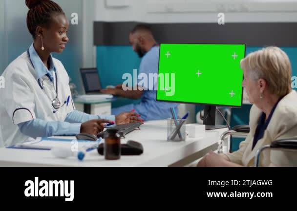 Female medic and paralyzed patient analyzing greenscreen on monitor ...