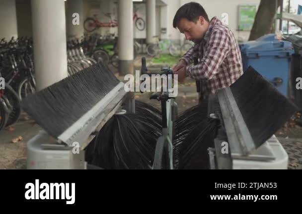 Male cyclist washes cycle in automatic bike shower with bicycle ...
