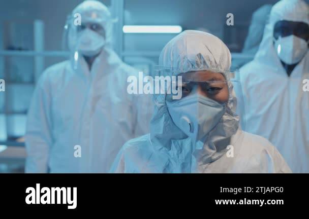 Close-up portrait of female Asian doctor and her blurred colleagues in ...