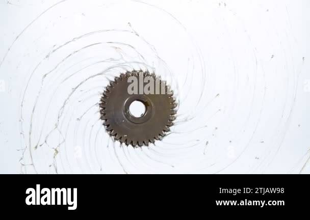 Super slow motion of rotating engine steel wheel with oil splashes ...