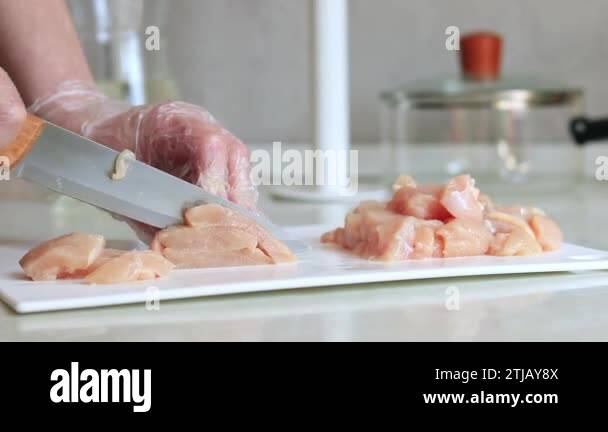 Cut fresh raw chicken meat with a sharp knife. Chicken fillet close-up ...