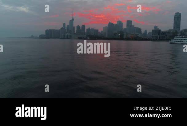 Flying over Toronto's beautiful sunset skyline, with a red hue in the ...