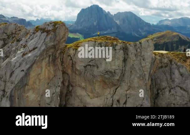 At the top edge of the Seceda ridgeline, a woman tourist captures ...