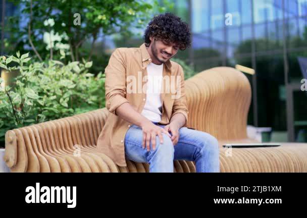 Young man suffers from painful severe knee joint ache while sitting on ...