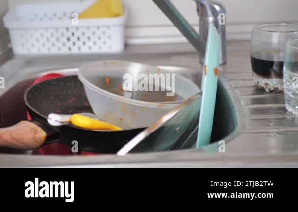 Sink full of dirty dishes. Close up panning shot of many neglected ...