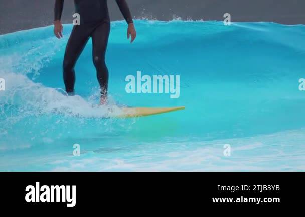 ARTIFICIAL WAVE POOL PARK, 05.05.2023: SLOW MOTION: Male surfboarder ...