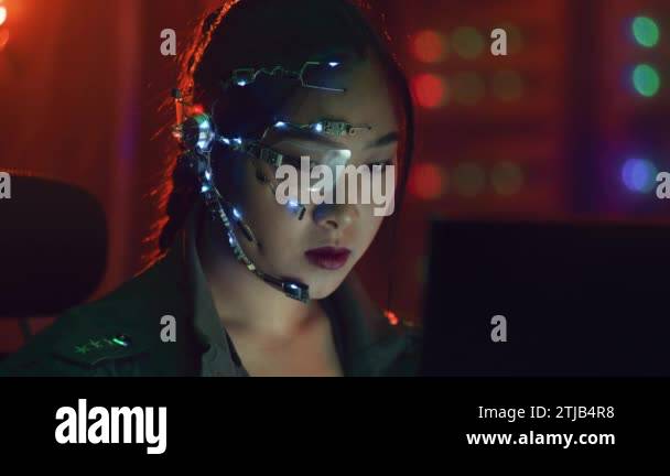 A Cyberpunk girl works on the computer in the red neon lights. Asian ...