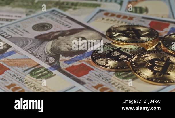 Bitcoin crypto-currency stacked with 100 dollar bills, close up ...