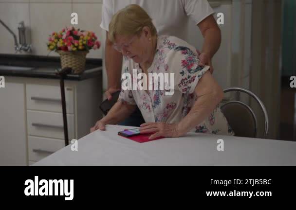 Elderly woman getting up from chair at home, authentic real life ...