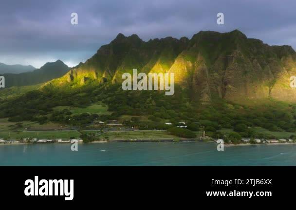 Scenic sunrise light shining at epic Kualoa Ranch mountain range ...