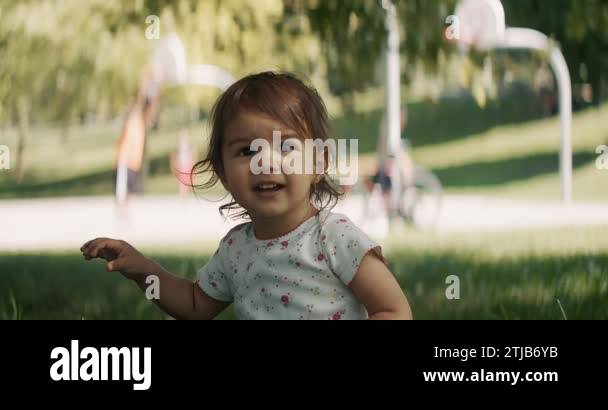 Cute baby girl exploring a park in summer. Real life, candid footage ...