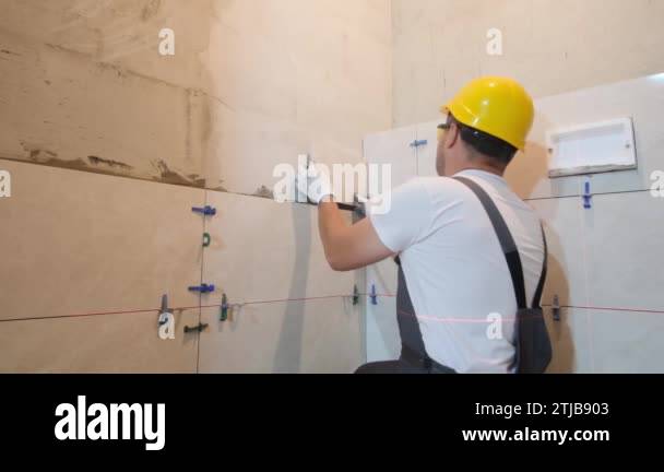Tile works. The tiler performs the work of laying tiles on the bathroom ...