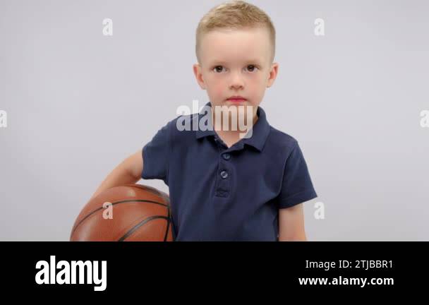 Kid boy with basketball ball in hands showing thumb up, saying yes and ...