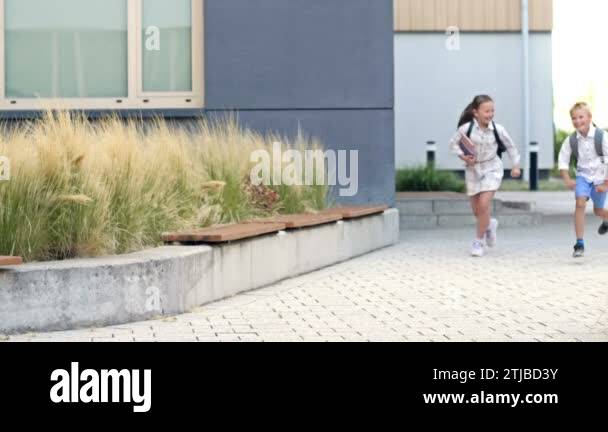 Back to school. Four first graders, two boys and two girls, are running ...