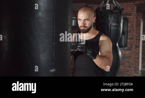 A guy in a sports uniform and with bandages on his hands practices ...